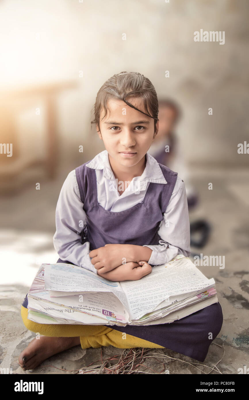 Girl sitting on the floor of her government primary school in uniform ...