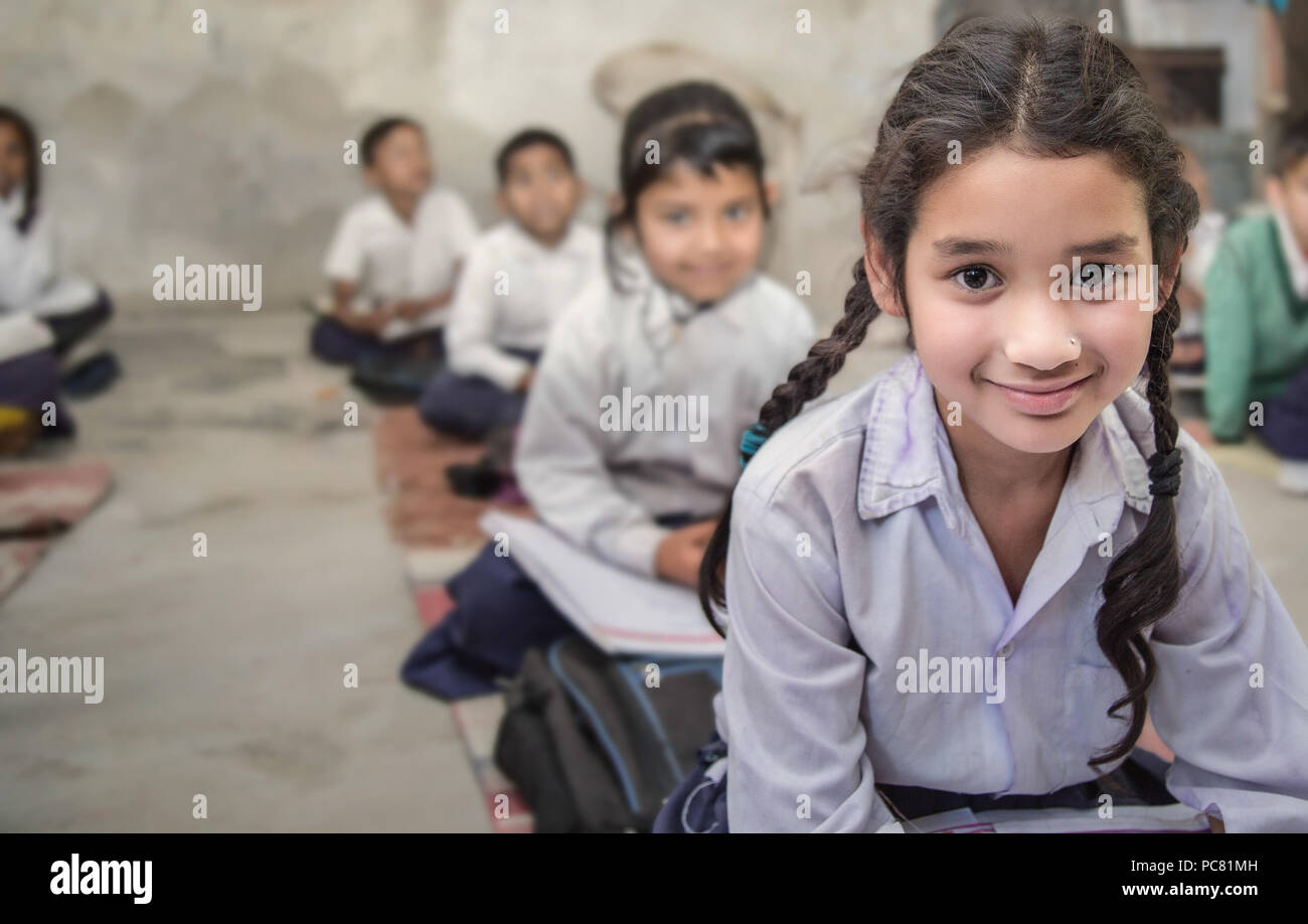 Girl sitting on the floor of her government primary school in uniform ...