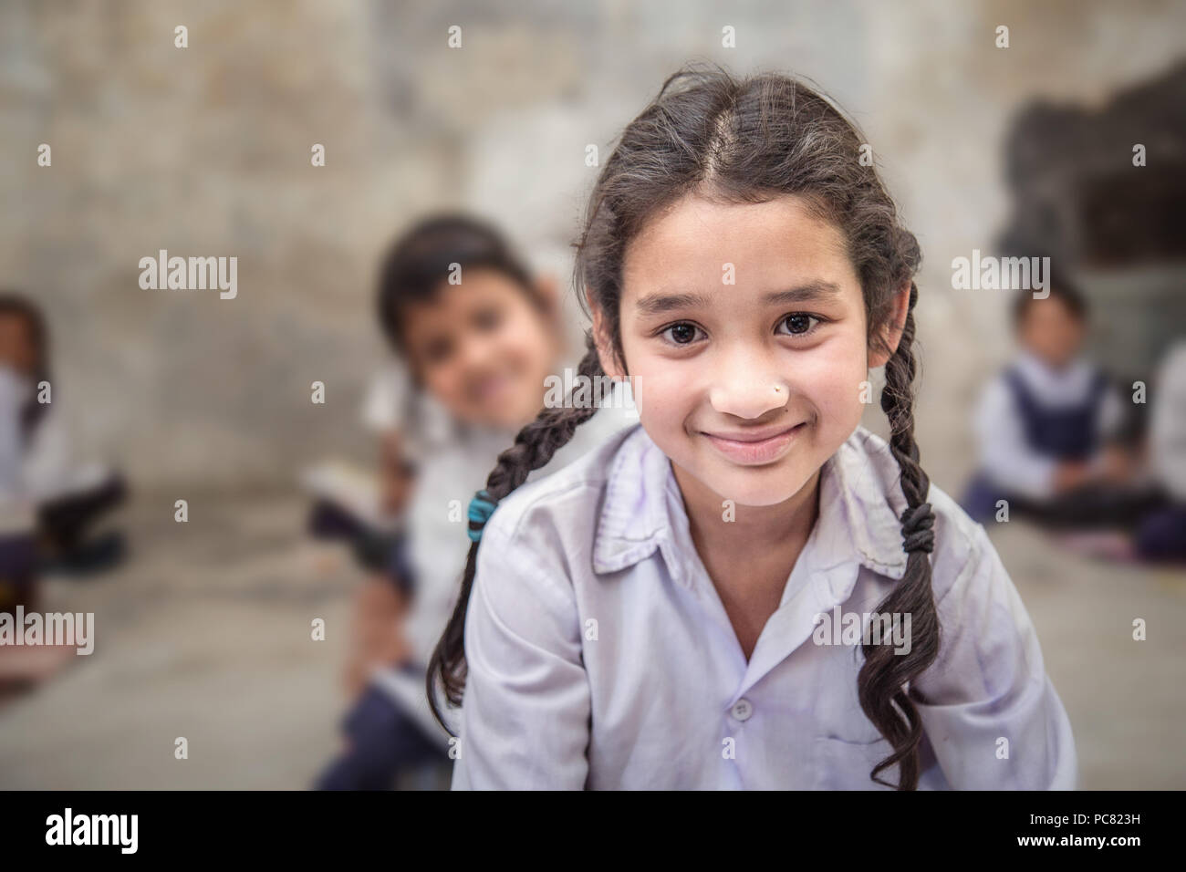 Girl sitting on the floor of her government primary school in uniform ...