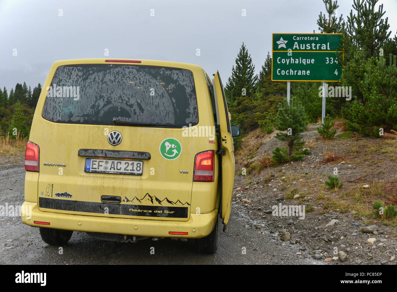 Yellow travel minibus on the Carretera Austral at Cochrane at road sign ...