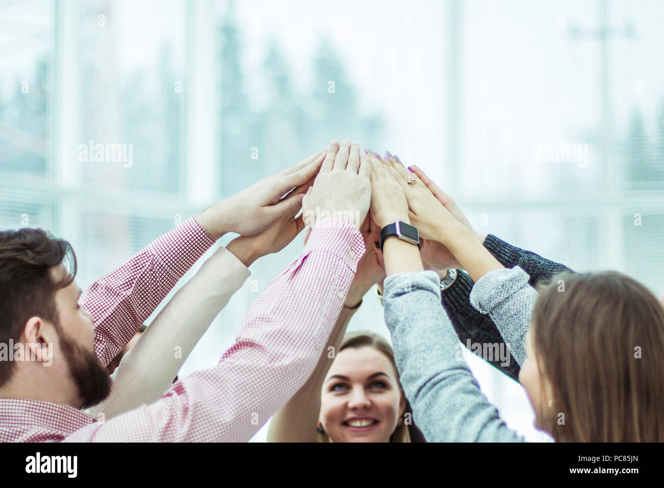 concept of teamwork:friendly business team standing in a circle and ...
