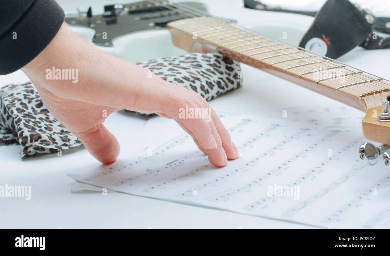 closeup of a guitarist touching sheet music .isolated on a white ...