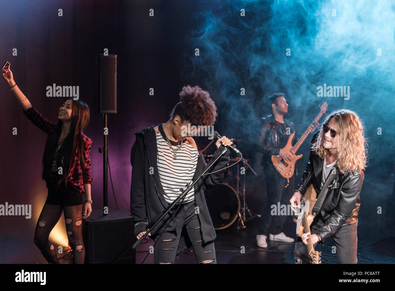 Female singer with microphone and rock and roll band performing hard ...