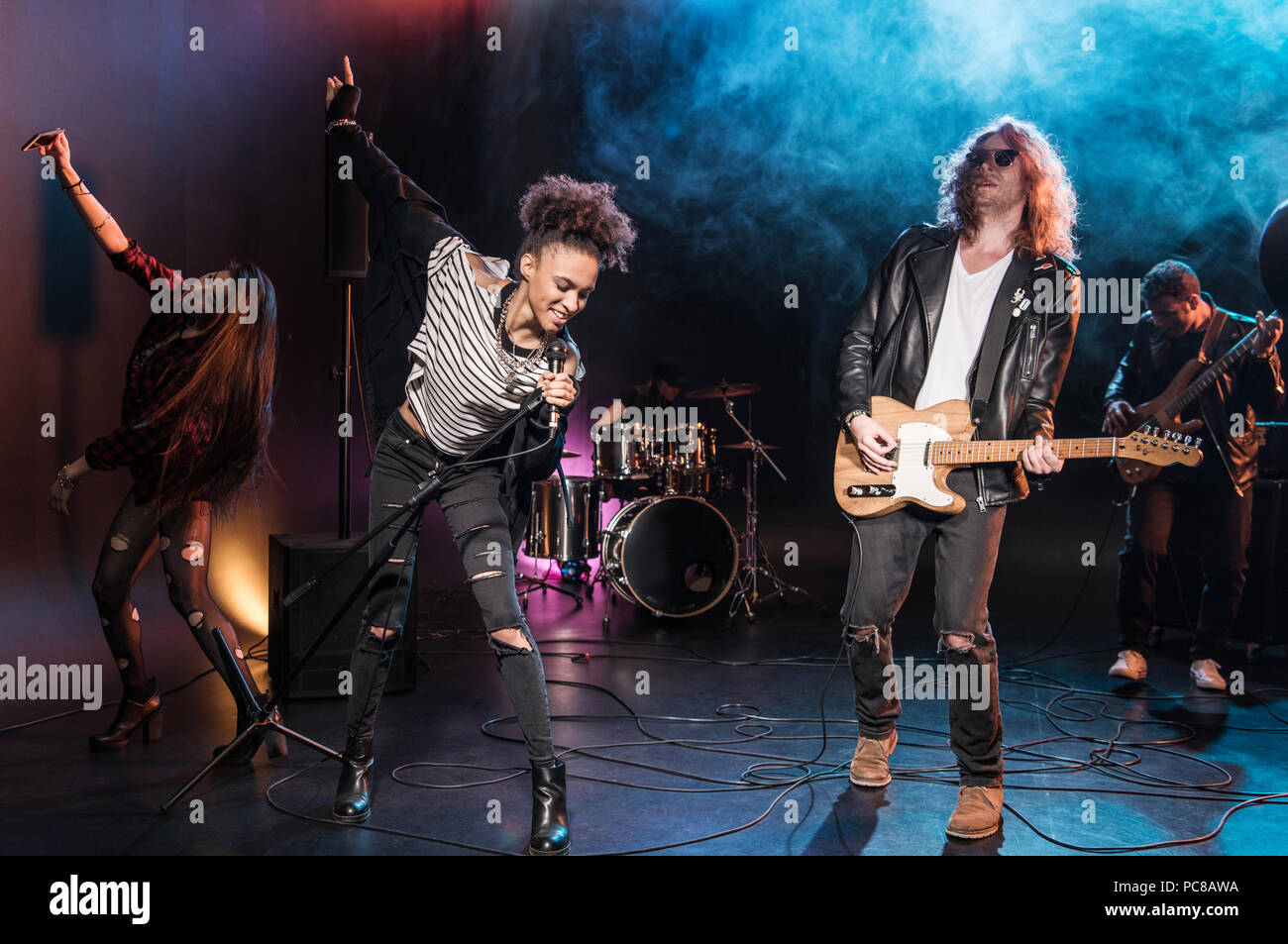 Female singer with microphone and rock and roll band performing hard ...