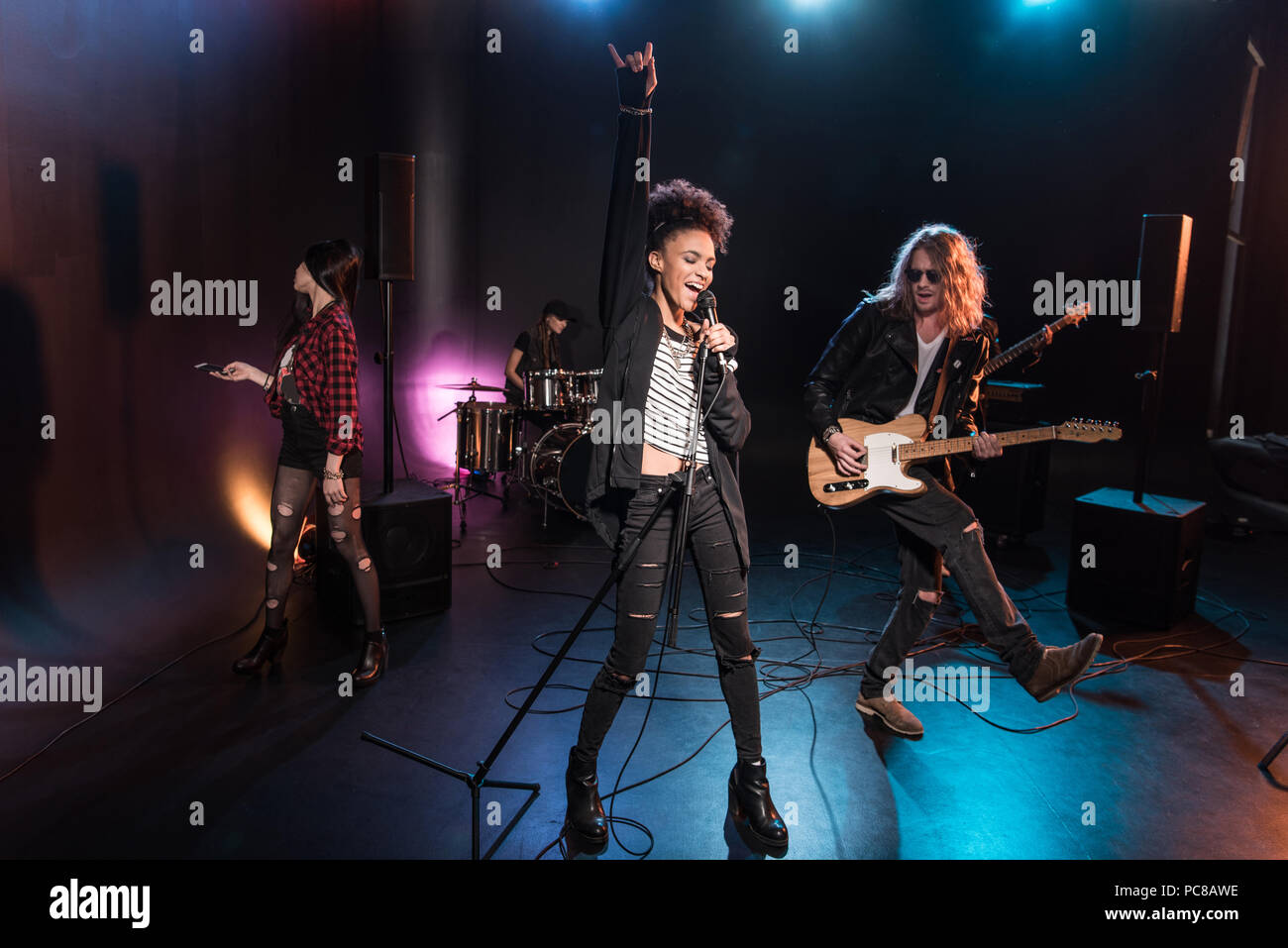 Female singer with microphone and rock and roll band performing hard ...