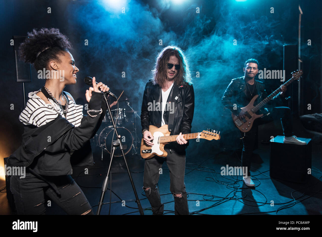 Female singer with microphone and rock and roll band performing hard ...
