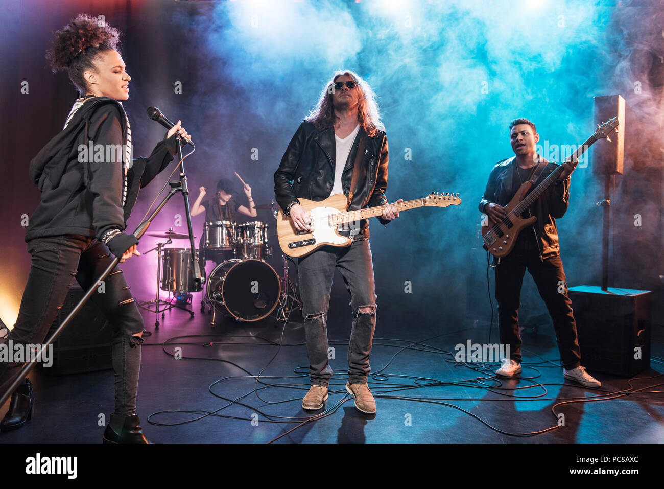 Female singer with microphone and rock and roll band playing hard rock ...