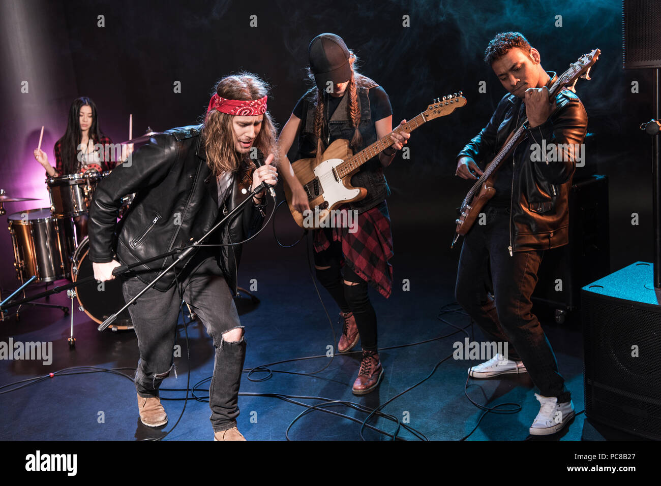 Handsome singer with rock and roll band performing music on stage Stock ...