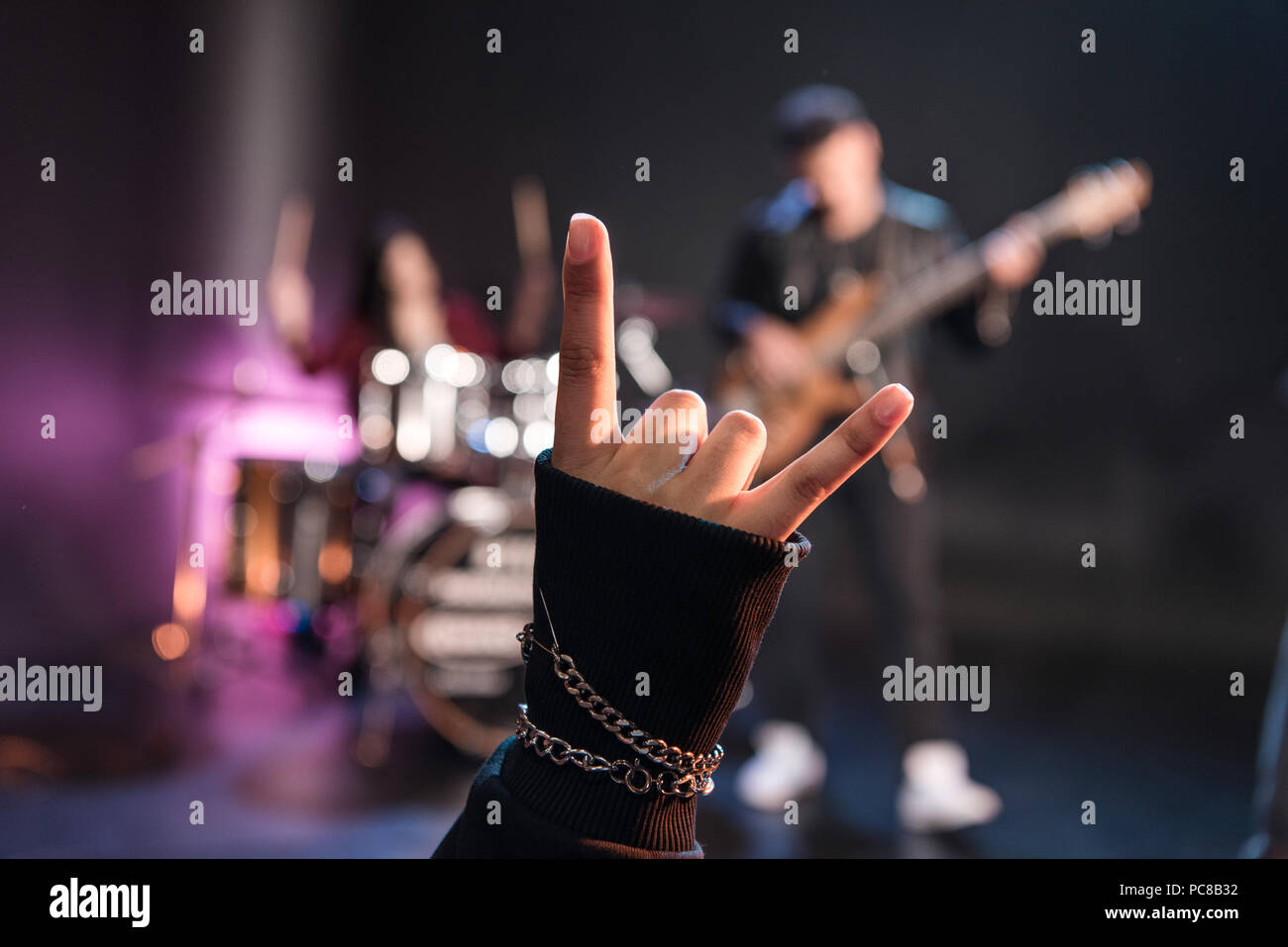Person showing sign of the horns while rock band playing on stage Stock ...