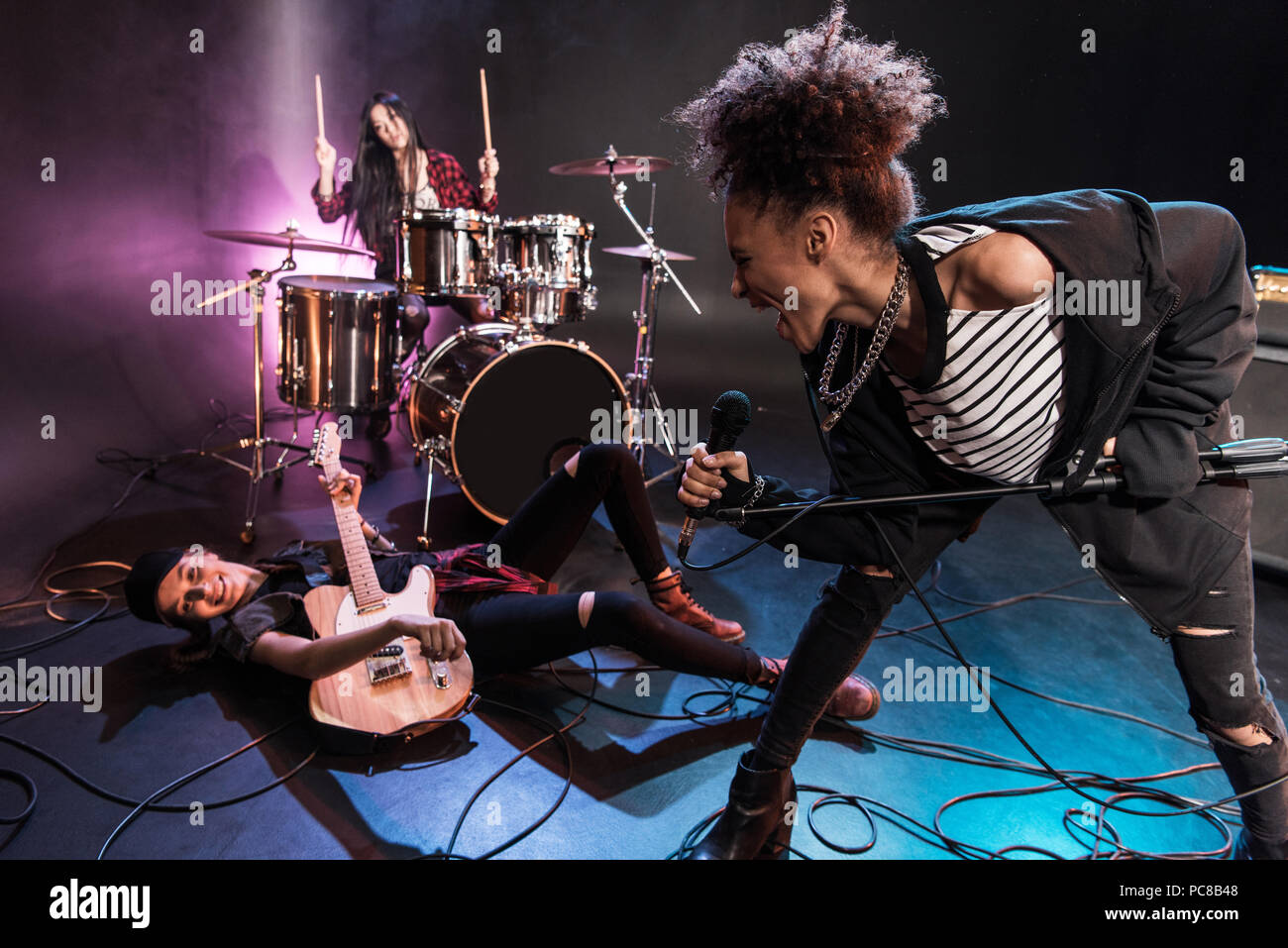 Young multiethnic rock and roll band performing concert on stage Stock ...