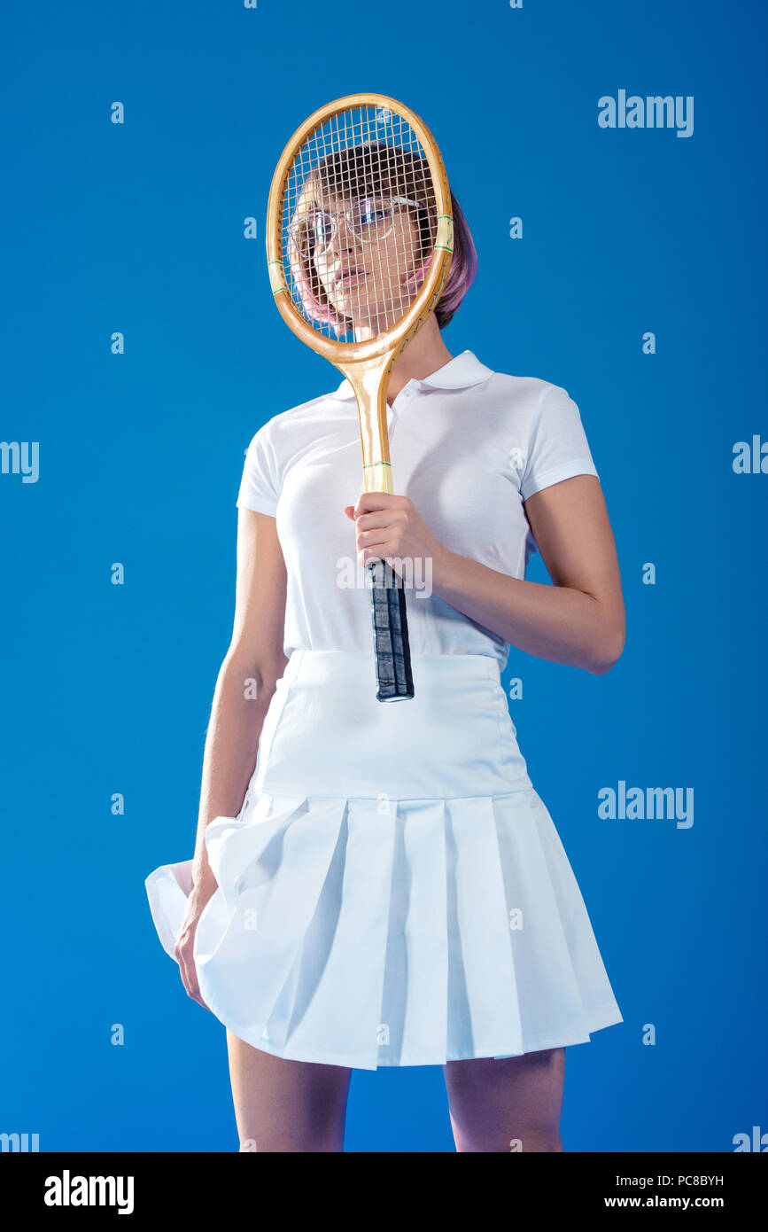 tennis player covering face with tennis racket isolated on blue Stock ...
