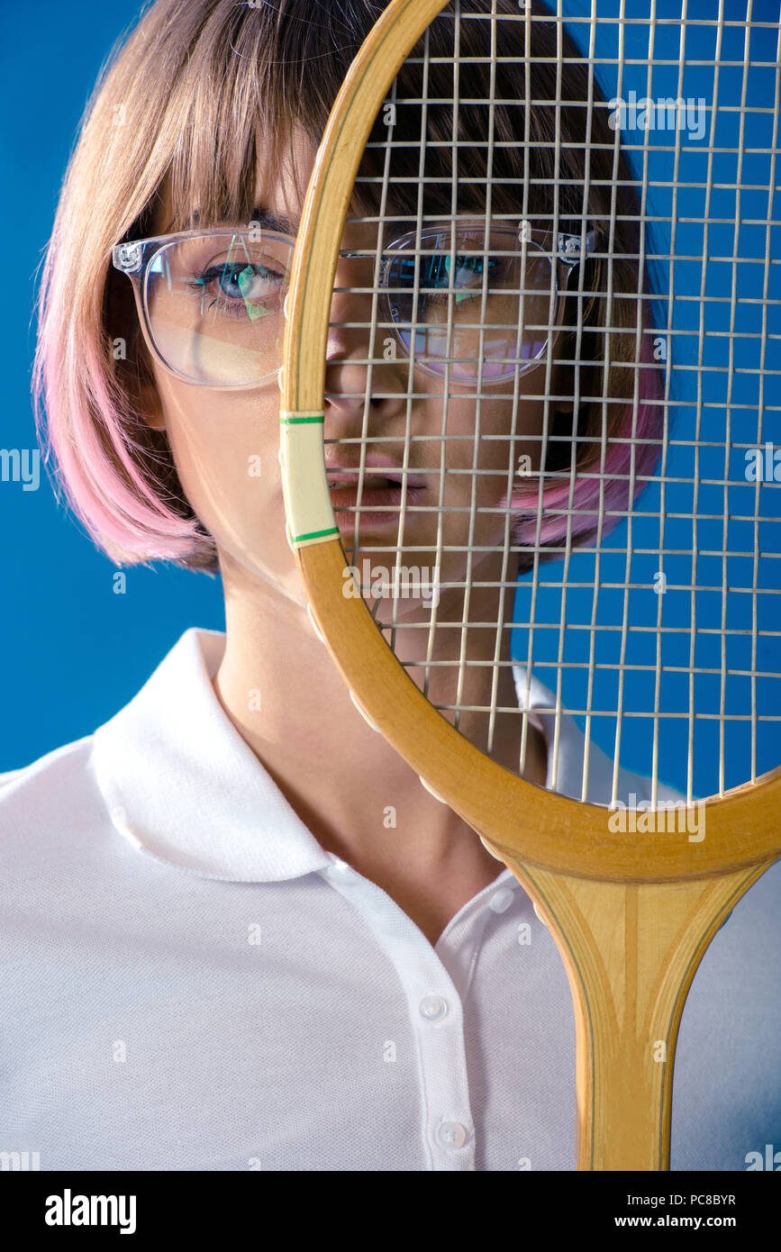 portrait of tennis player covering half of face with tennis racket ...