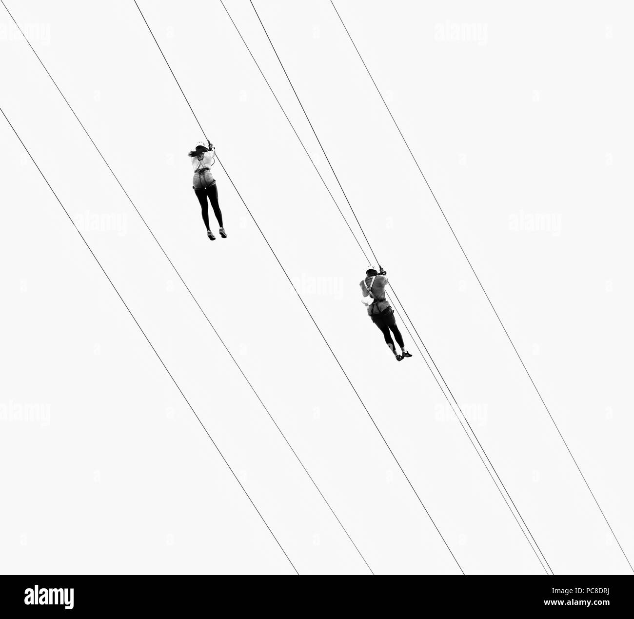 Two people on high wire Stock Photo - Alamy