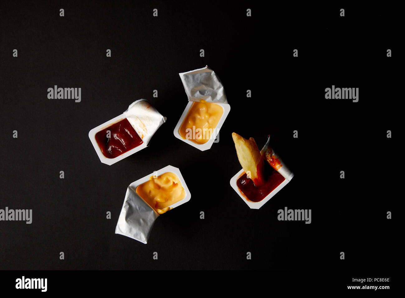 top view of plastic containers with sauces and poured french fry ...