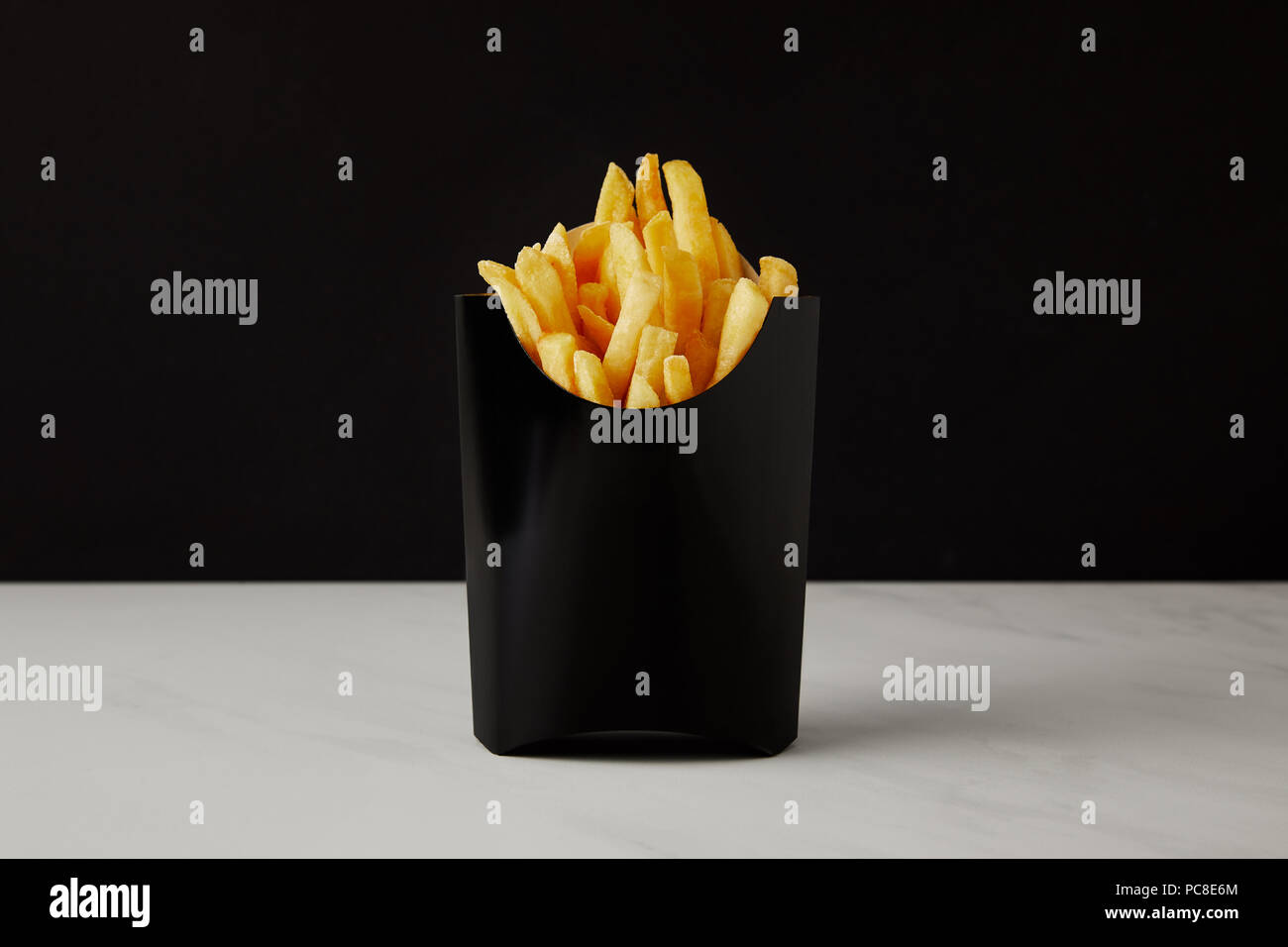 box of french fries on white marble surface isolated on black Stock ...