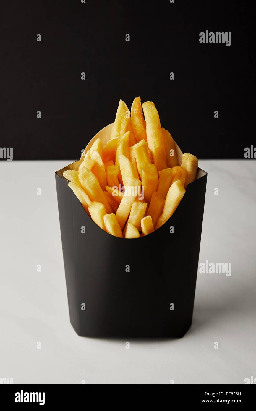 close-up shot of box of french fries on white marble surface isolated ...