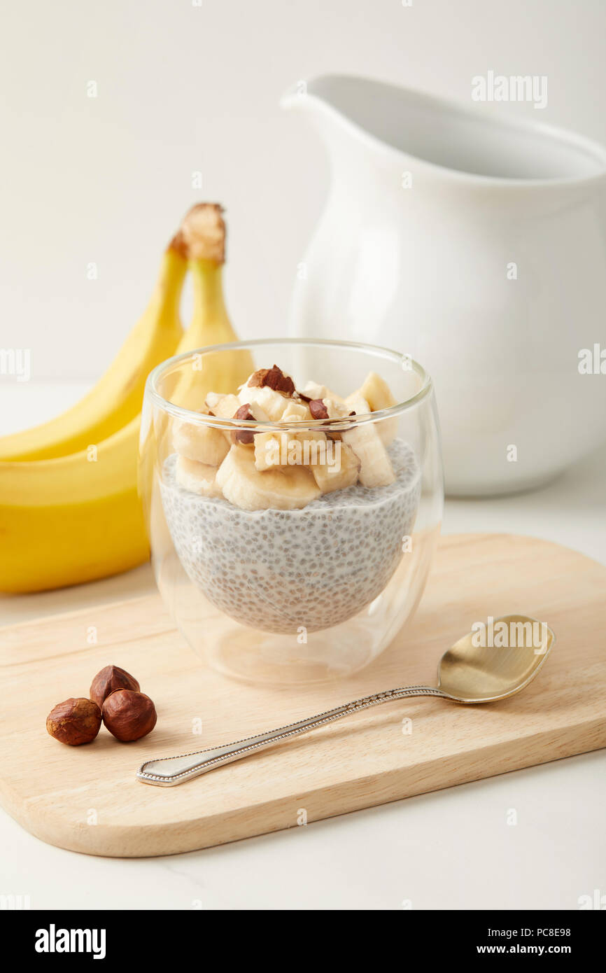 close up view of chia seed pudding with pieces of banana and hazelnuts ...