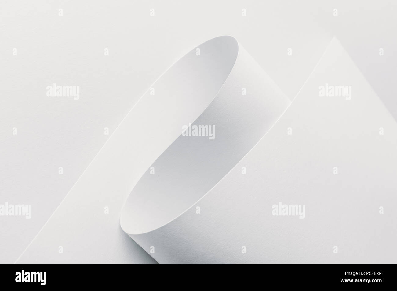 Close-up view of white rolled paper on white background Stock Photo - Alamy