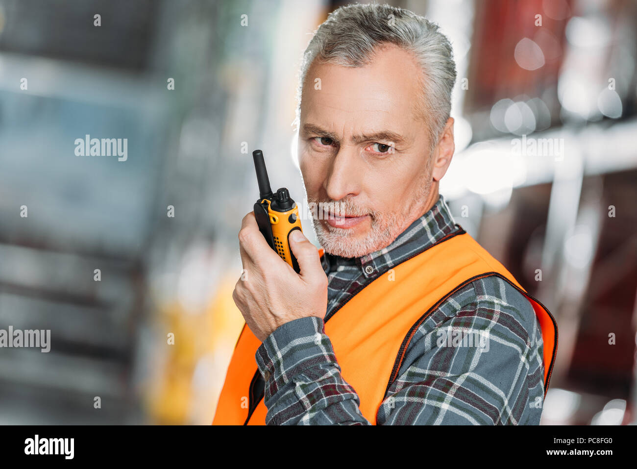 senior worker using walkie talkie in shipping stock Stock Photo - Alamy