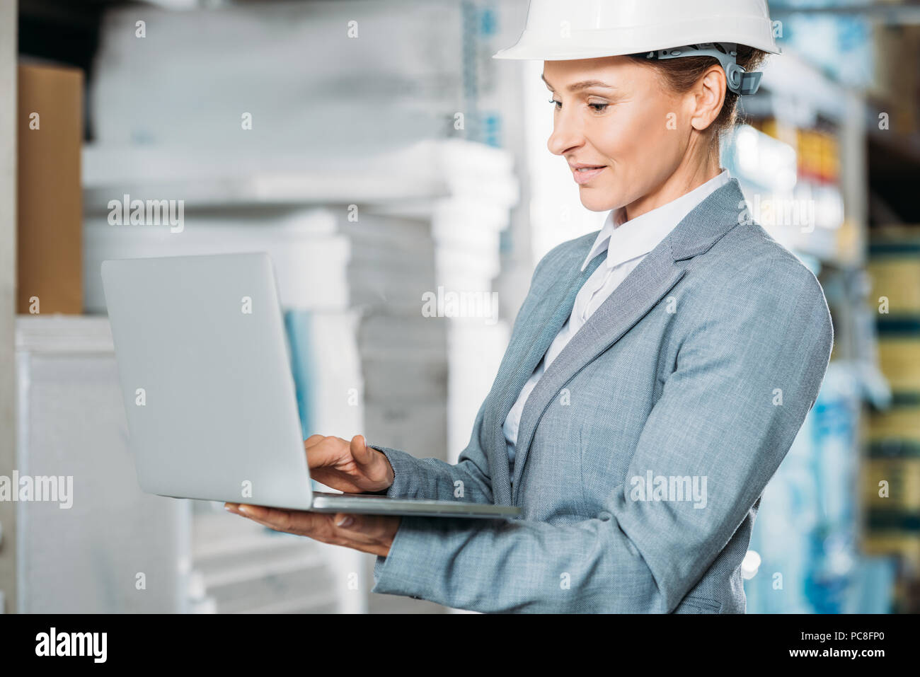 female inspector in helmet with laptop in warehouse Stock Photo - Alamy