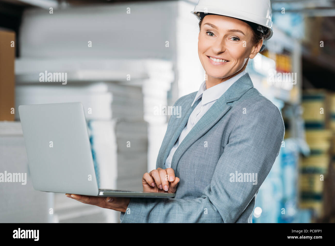 female inspector in helmet with laptop in warehouse Stock Photo - Alamy