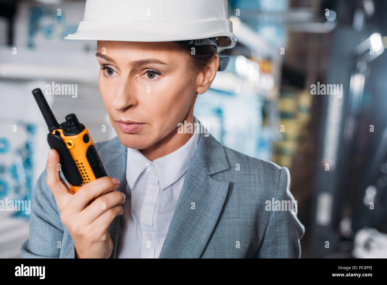 female inspector in helmet with walkie talkie in warehouse Stock Photo ...