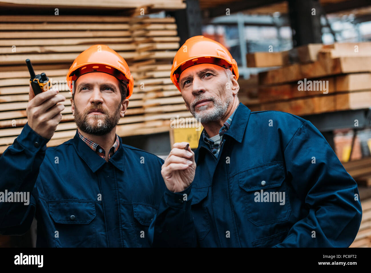 two builders in helmets working outside on construction Stock Photo - Alamy
