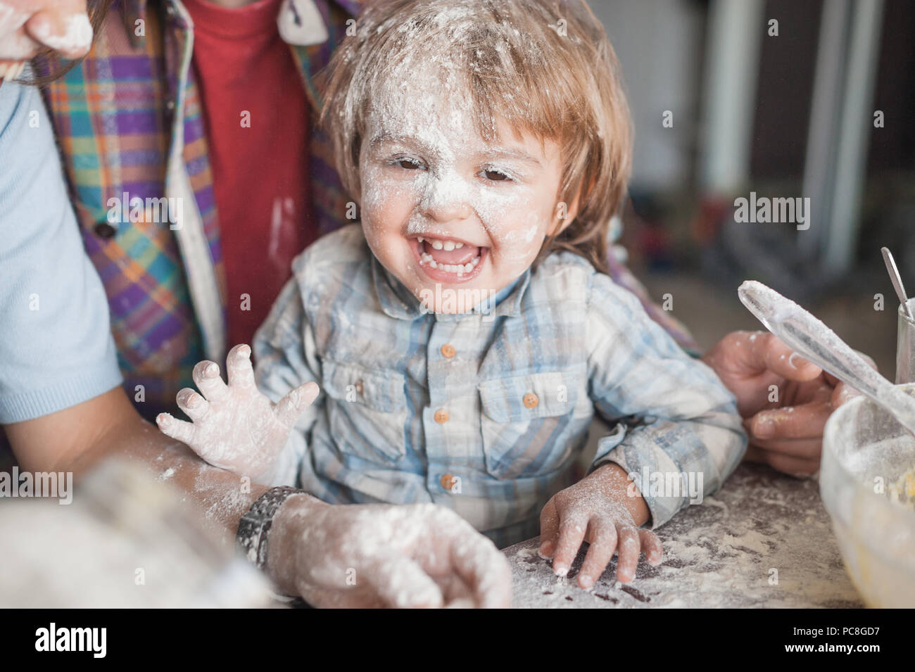 laughing little boy covered with flour while cooking with parents Stock ...