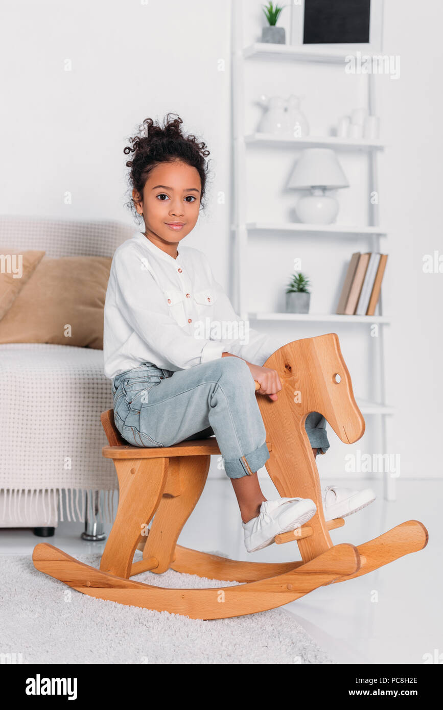 side view of african american kid sitting on wooden rocking horse Stock ...