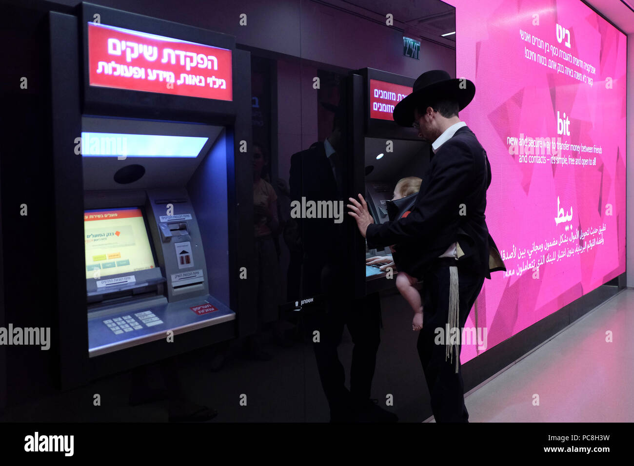 An ultra orthodox Jew using cash machine in ATM cash point in a branch ...
