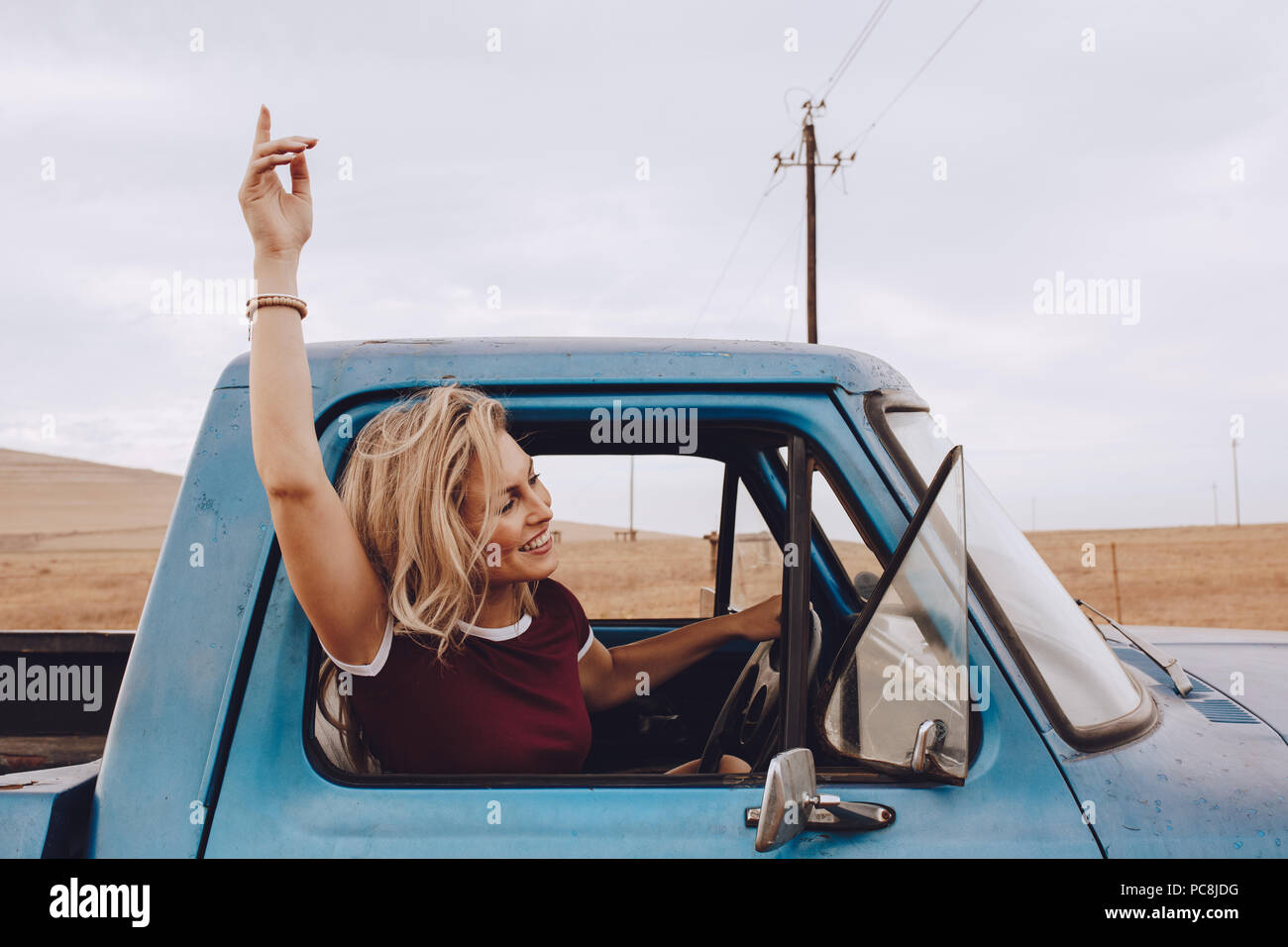 Beautiful young woman driving a car and enjoying road trip. Excited ...