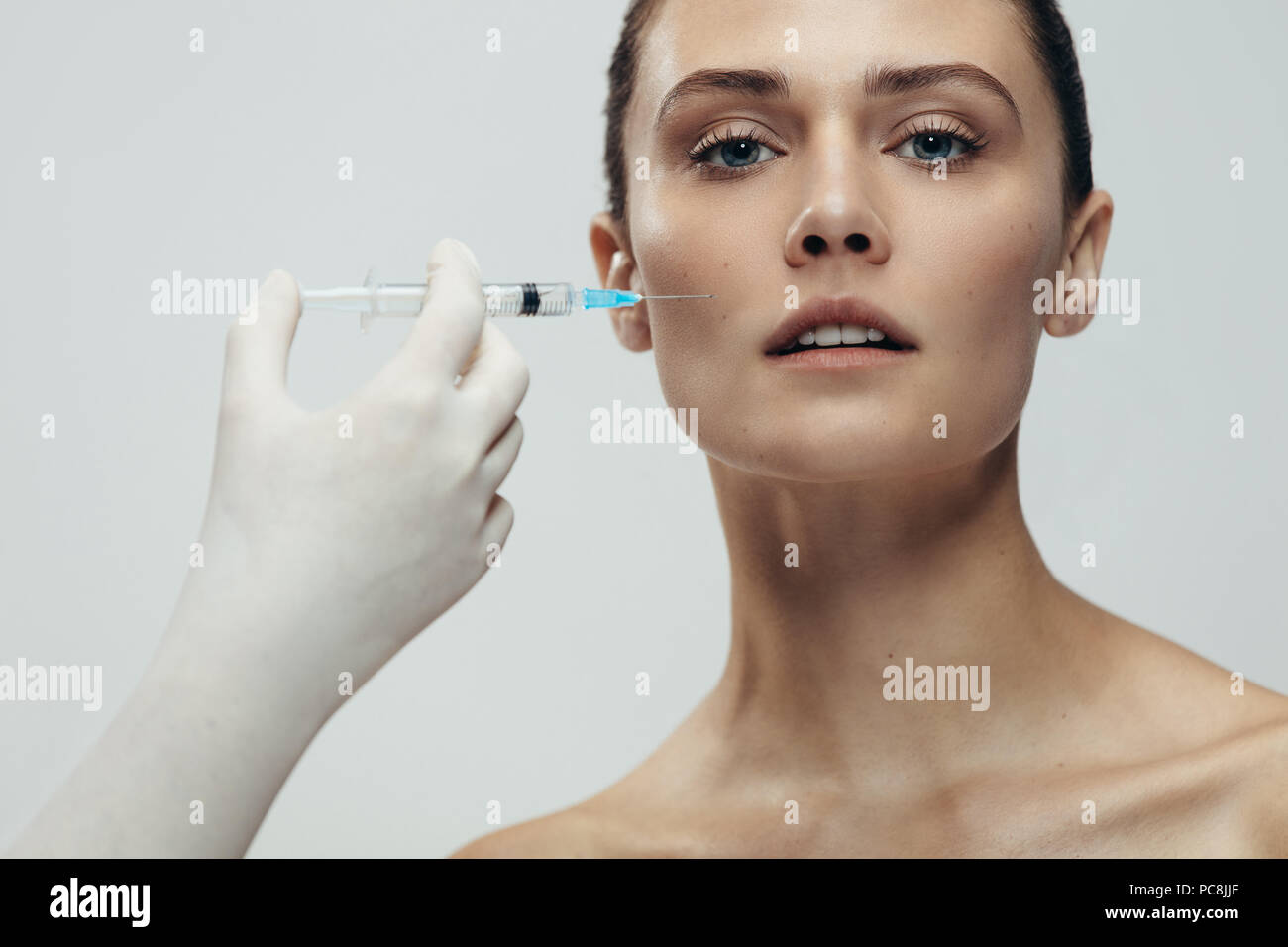 Beautiful woman gets injection in her face. Female under the plastic ...
