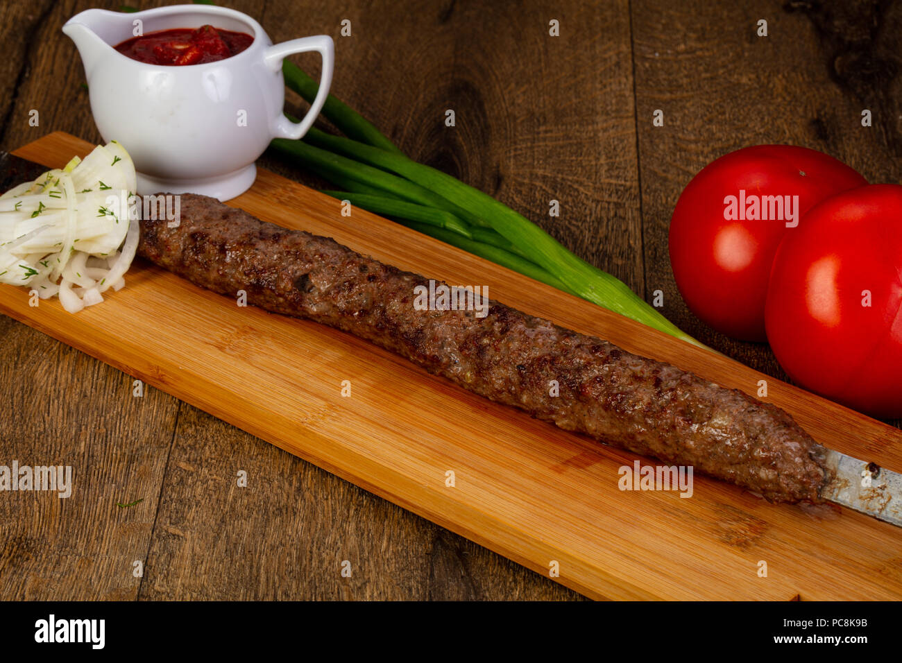 Grilled kebab minced meat with sauce and onion Stock Photo - Alamy