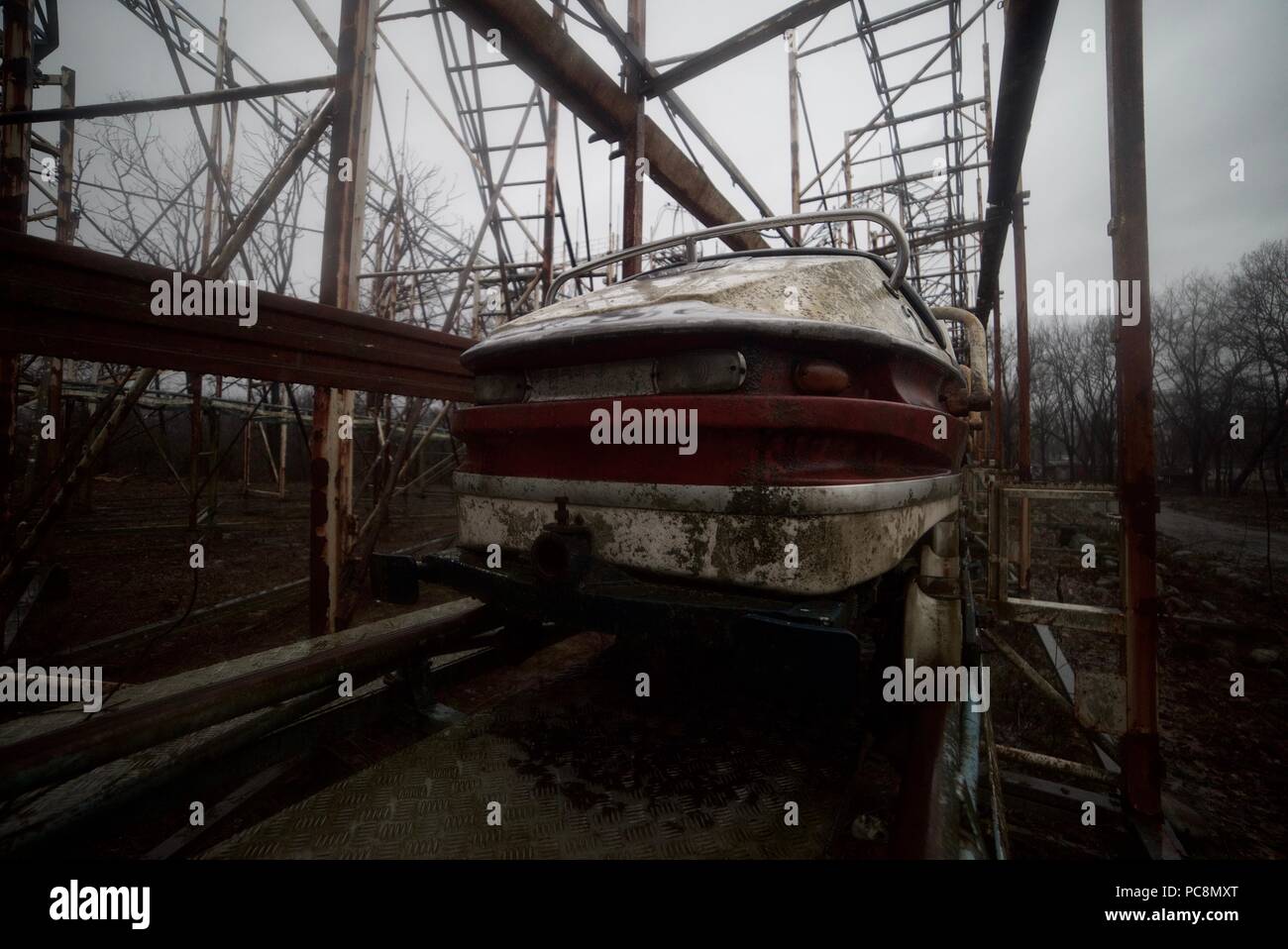 An abandoned roller coaster train on an disused roller coaster track in ...
