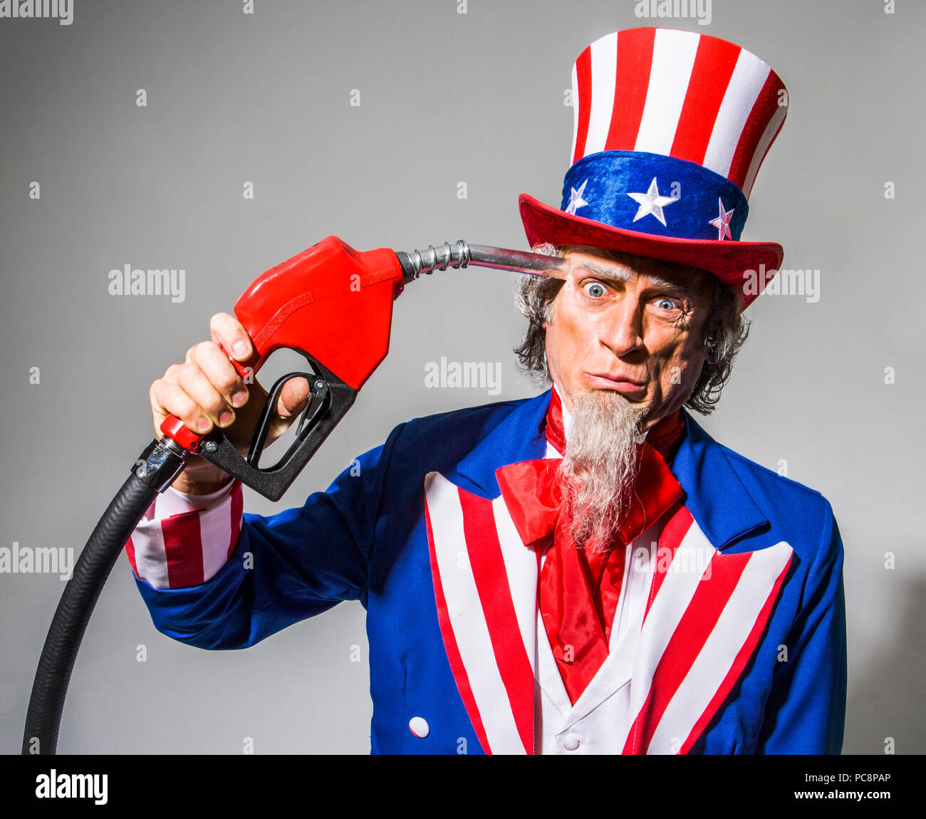 Uncle Sam standing with a gas pump nozzel held in front of him ...