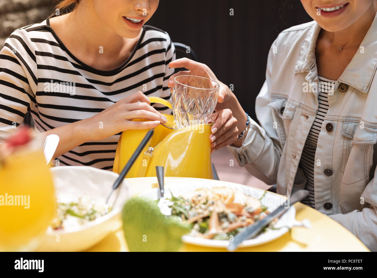 Glass from cafeteria. Two young female criminals feeling risky while ...