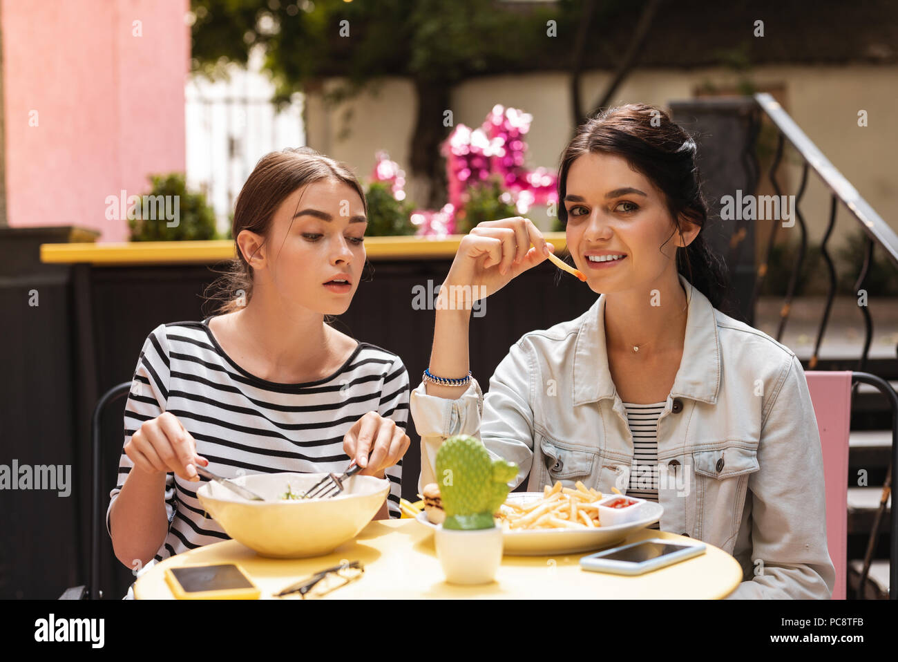 Feeling jealous. Dark-haired woman eating green garden salad feeling ...