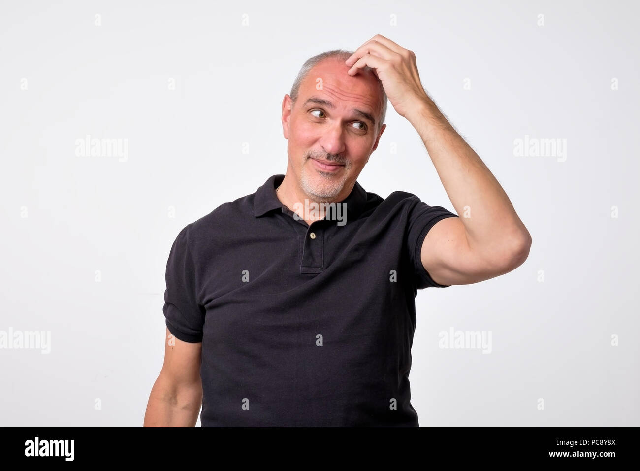 Spanish mature man scratching his forehead with doubt. I do not know ...