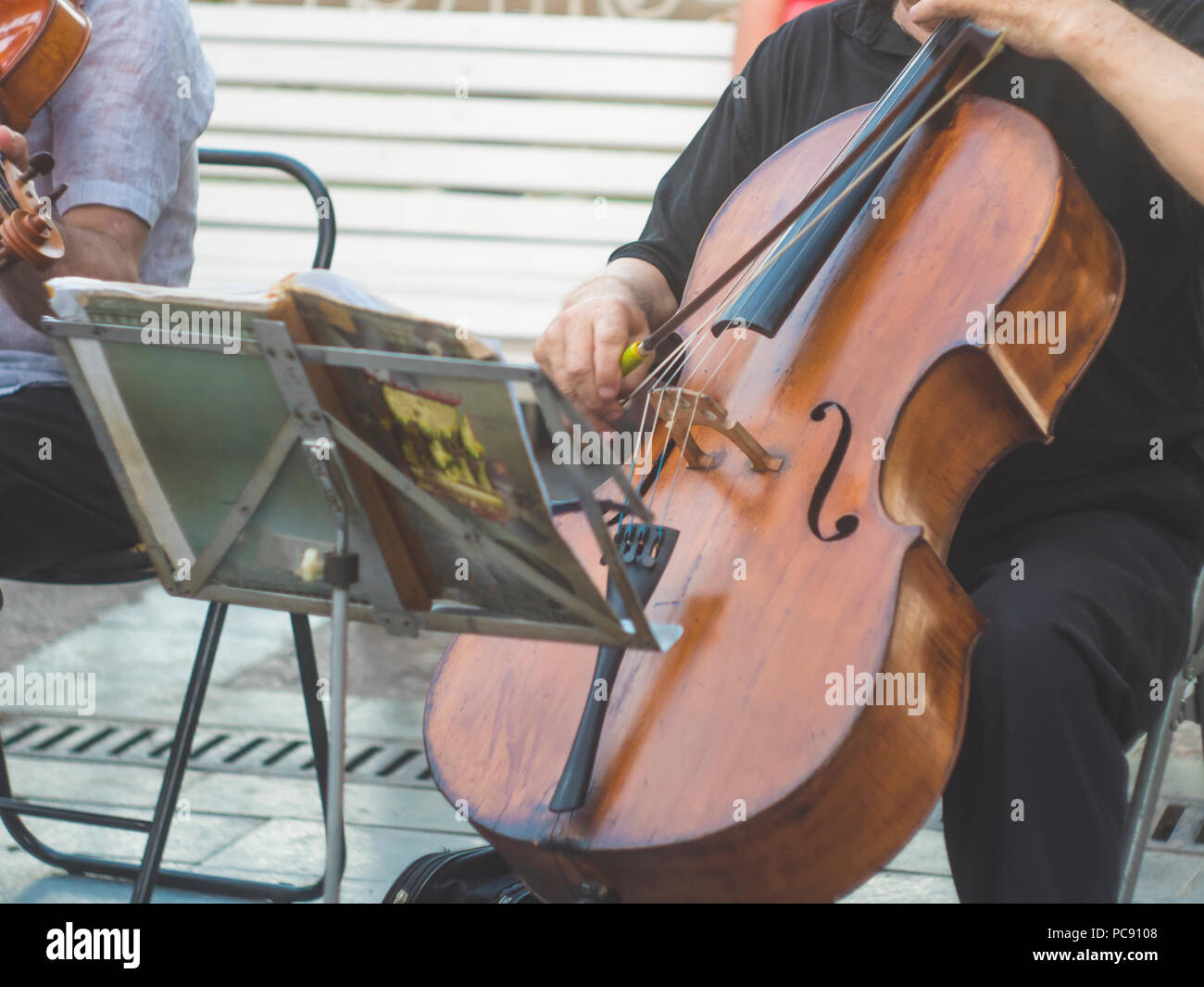 cellist musician group perform music in the street, close up man ...