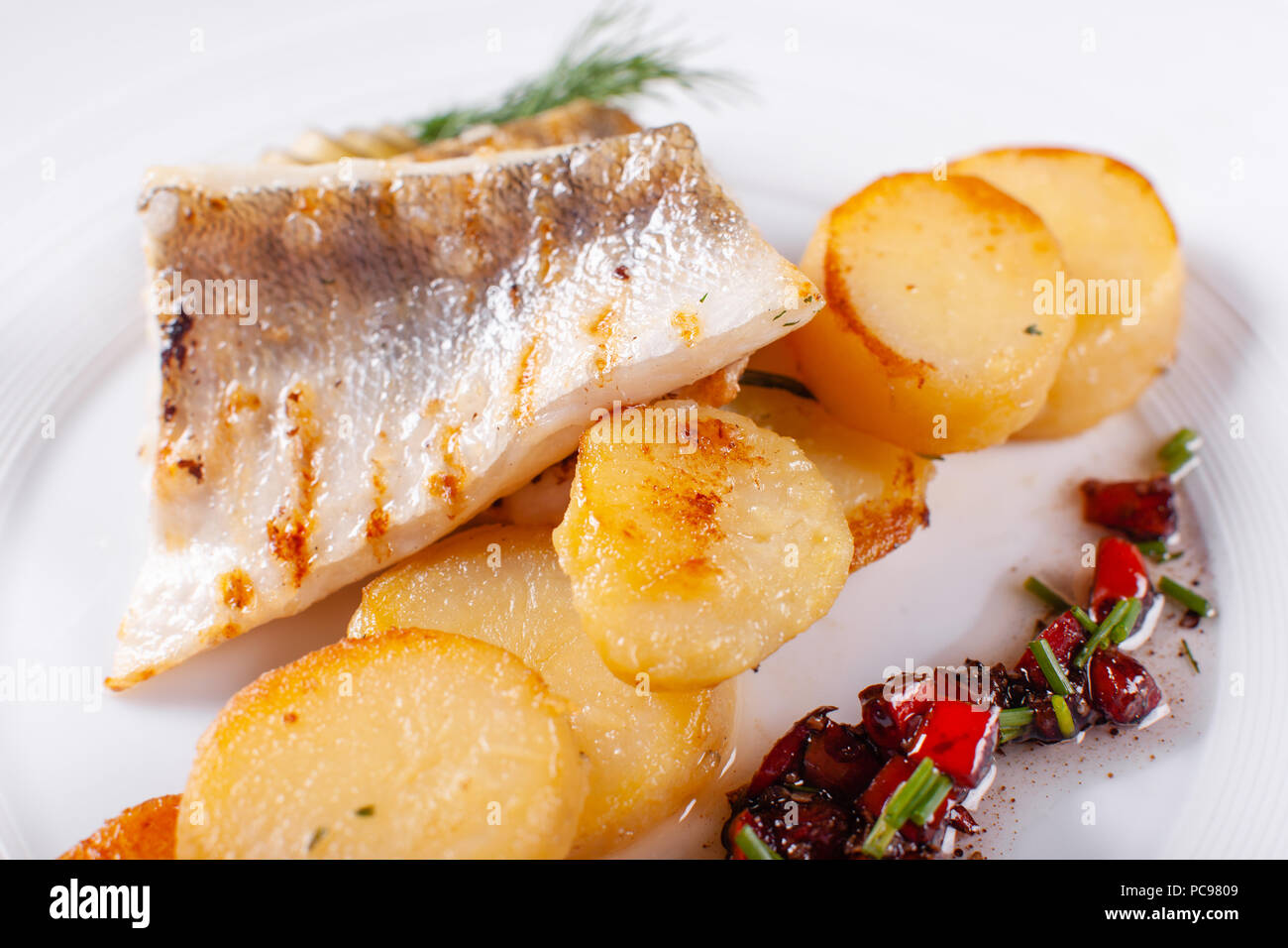 Roasted cod, codfish with baked potatoes and vegetables with pickled ...