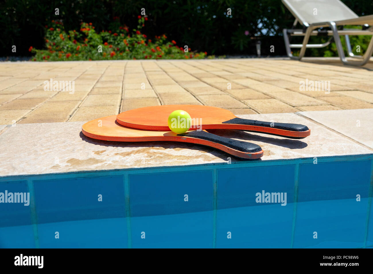 A bat and ball ping pong game beside the swimming pool Stock Photo - Alamy