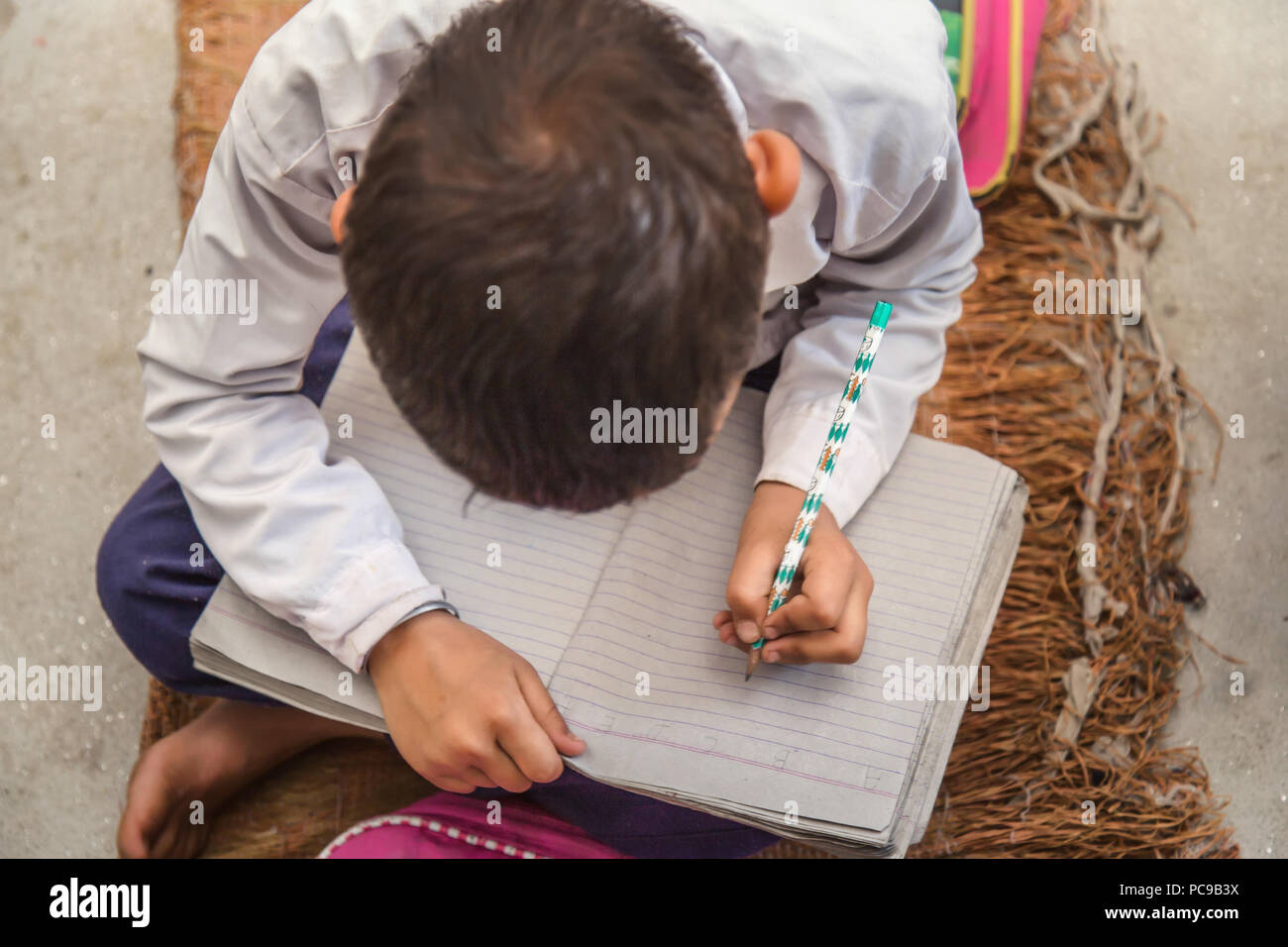 A Indian village school boy with his notebook and pencil, studying in ...