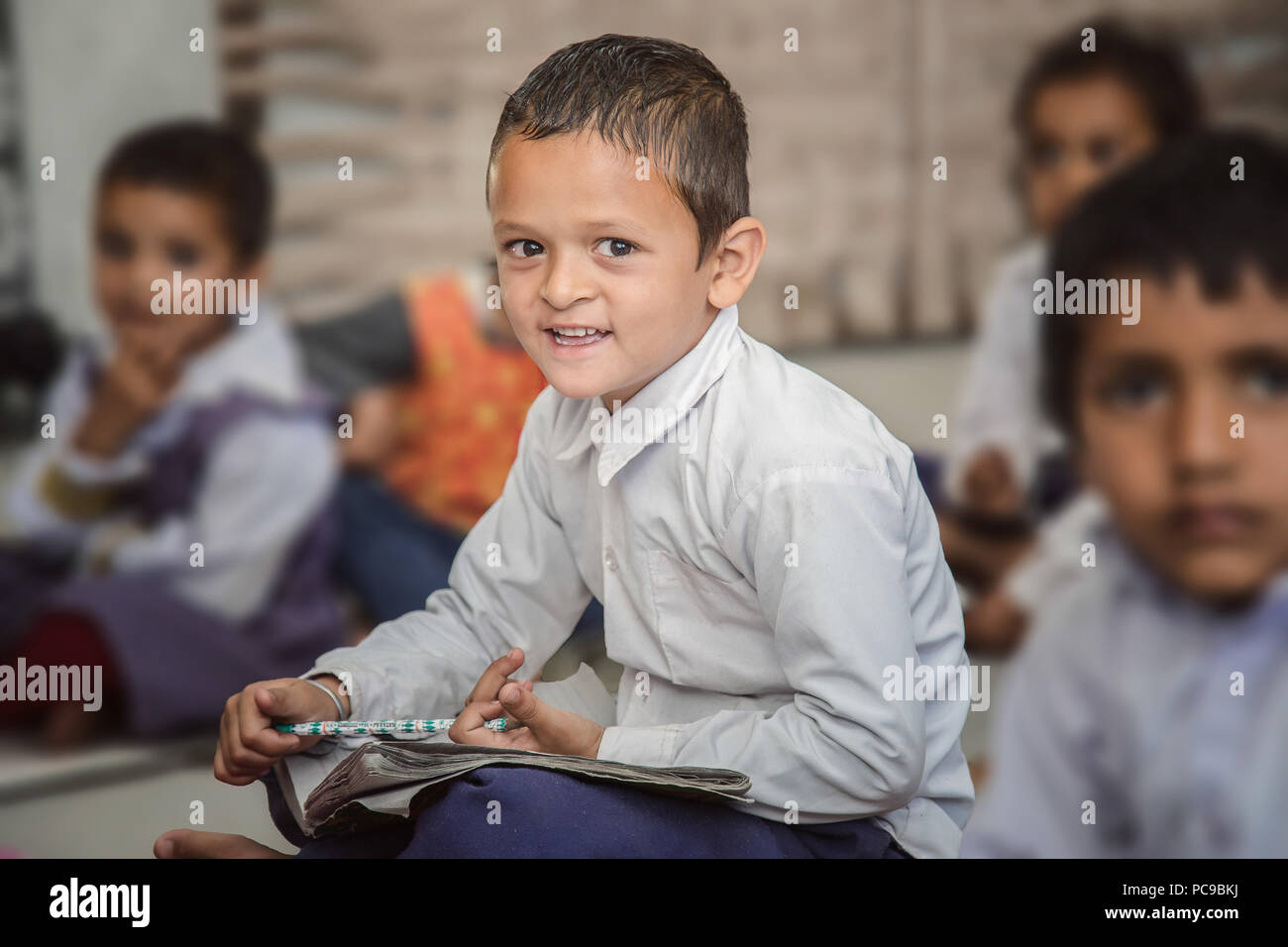 Happy Indian/Asian poor village school boy sitting in classroom ...