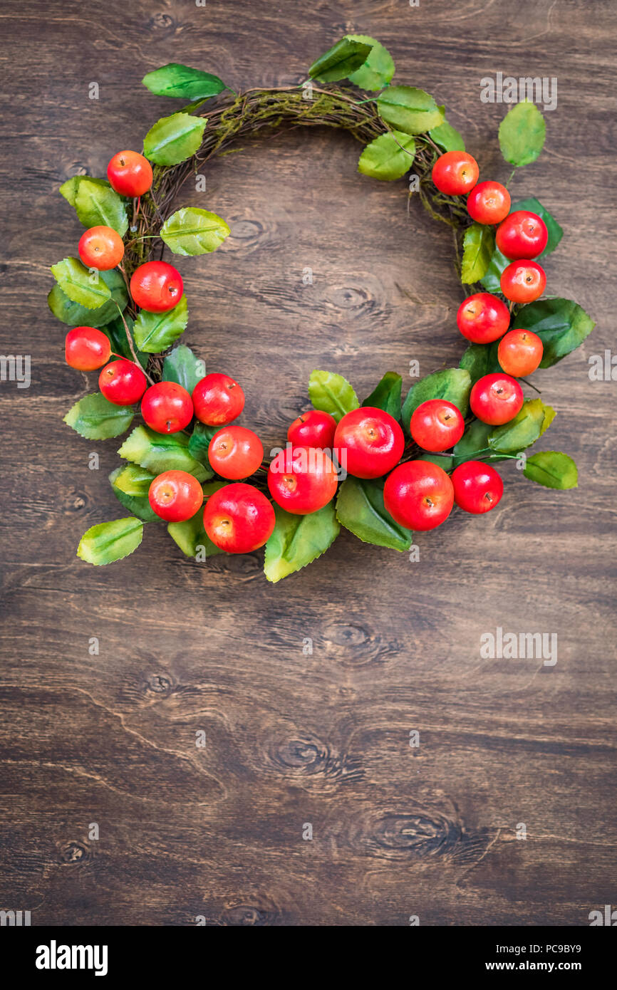 A colorful wreath of small red apples on the wooden background Stock ...