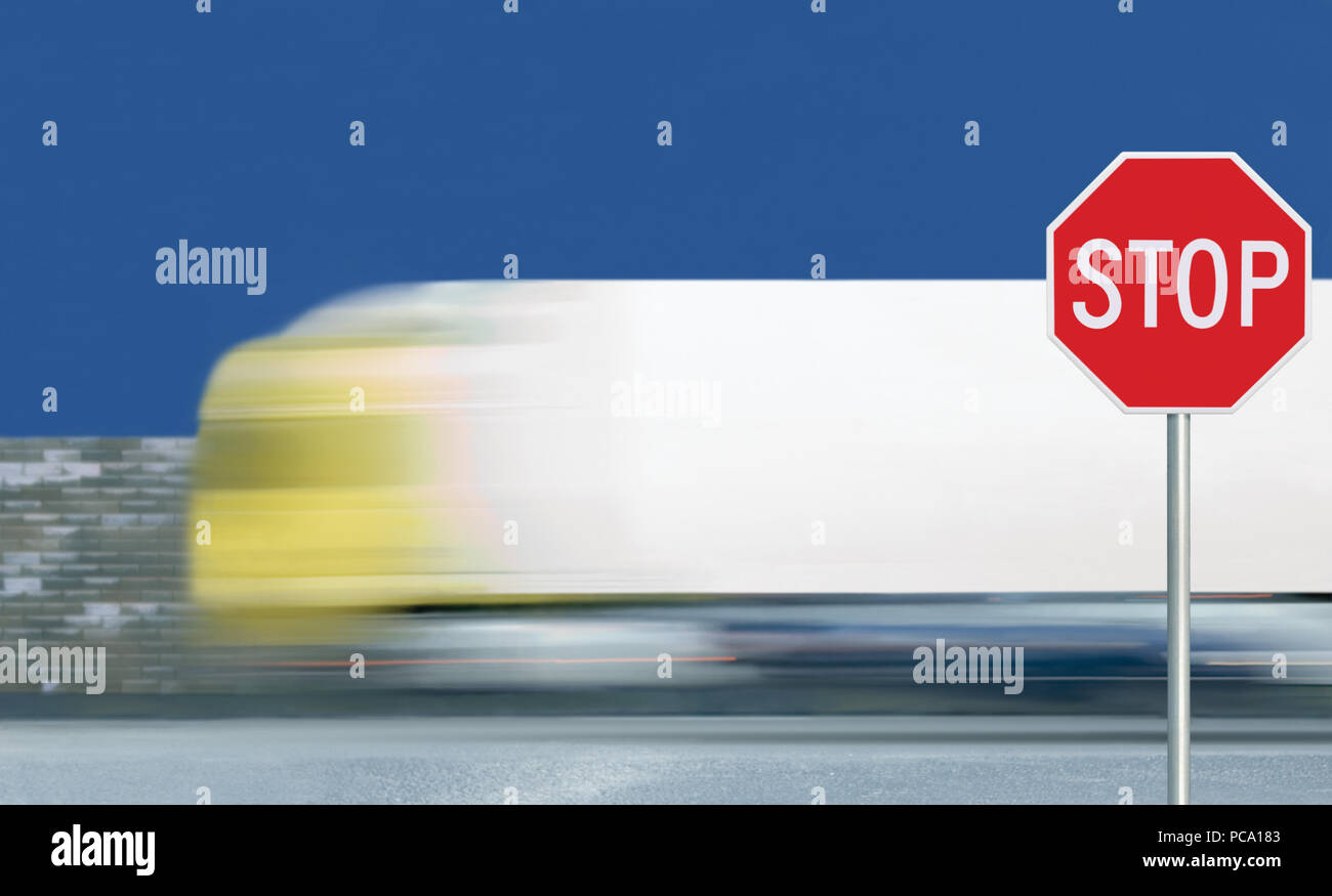 Red stop road sign, motion blurred truck vehicle traffic background ...