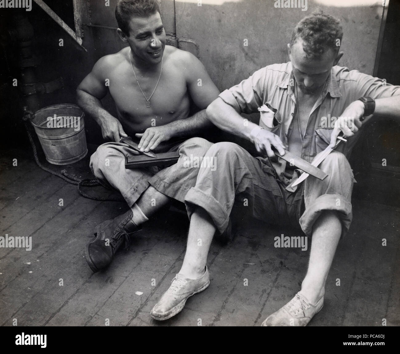 World War II Photo - Two marines sharpen their knives before going onto ...