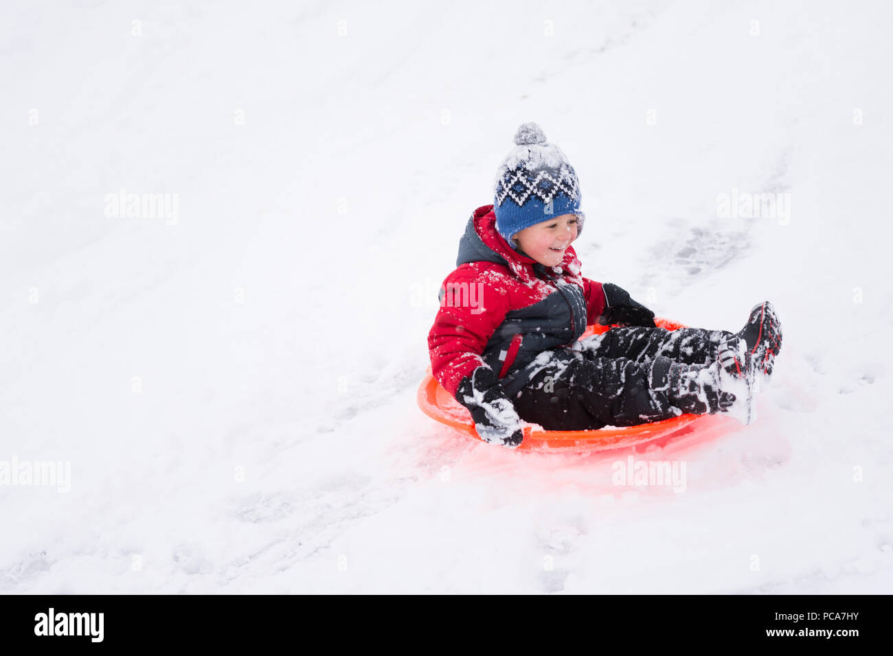 Boy sledding down hill hi-res stock photography and images - Alamy
