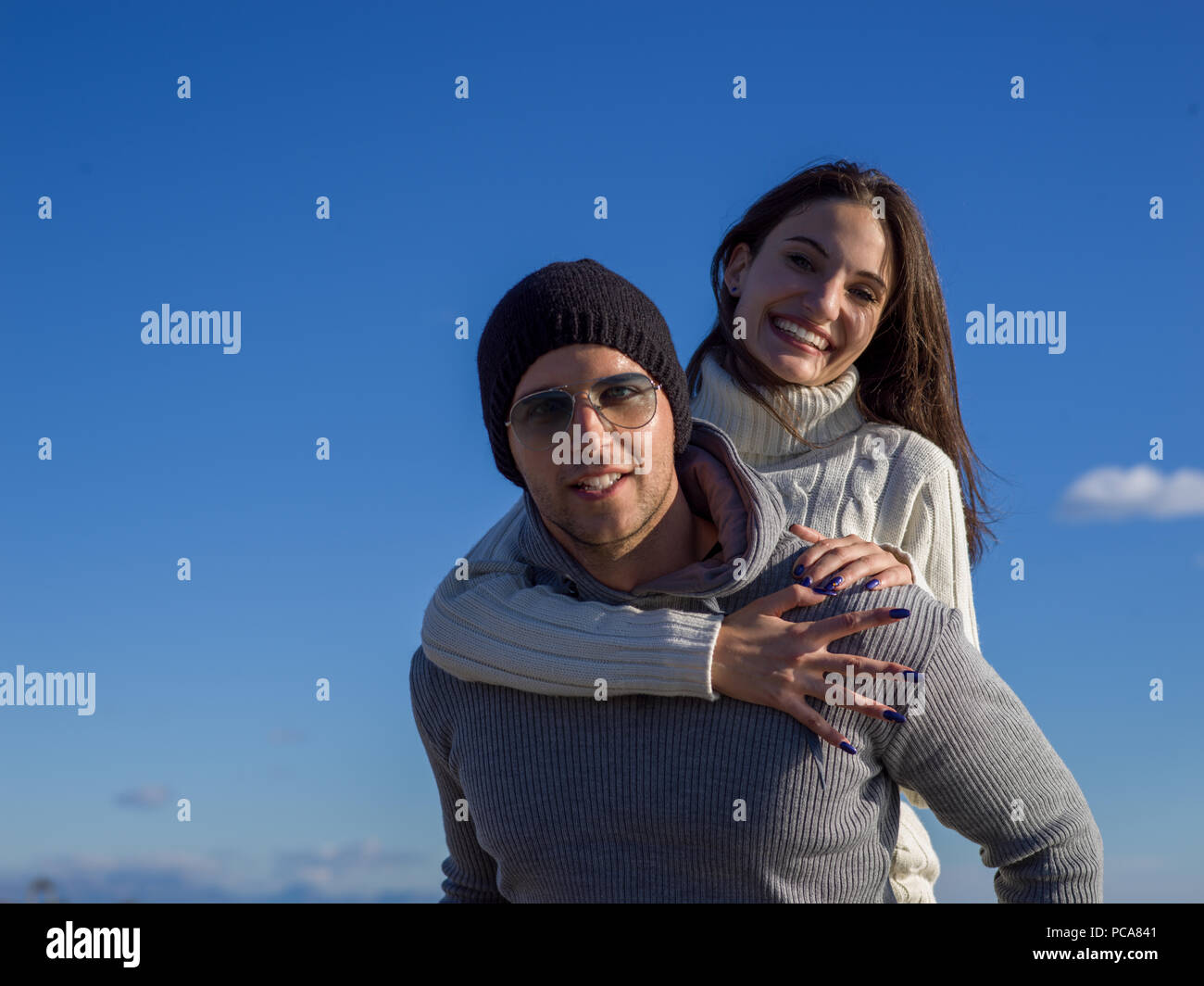 Men Giving Piggy Back Rides At Sunset By The Sea, autumn time Stock ...