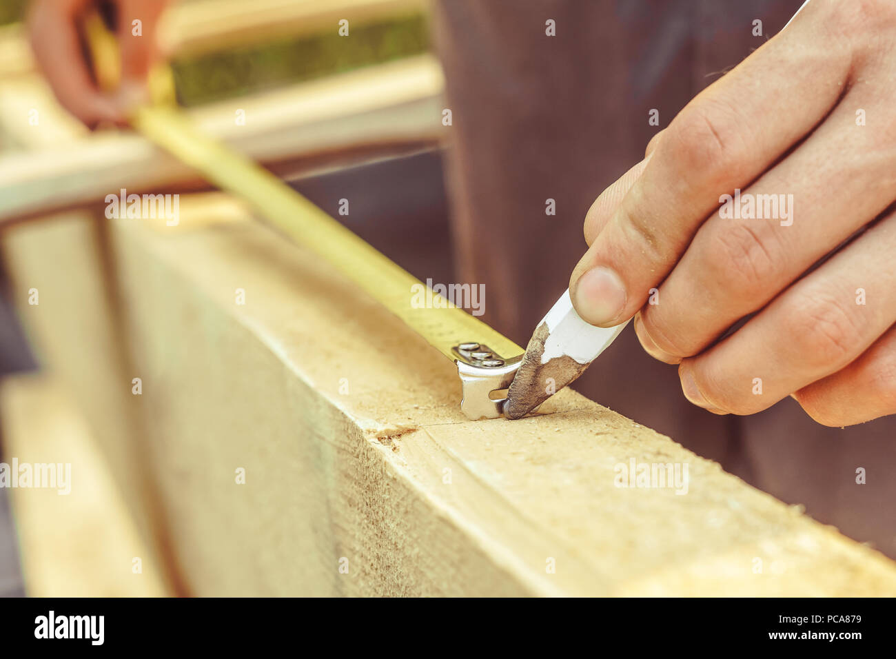 The worker makes measurements of a board with the help of a ruler, a ...