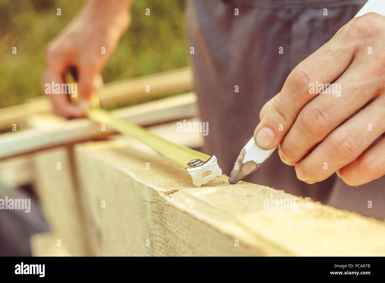 The worker makes measurements of a board with the help of a ruler, a ...